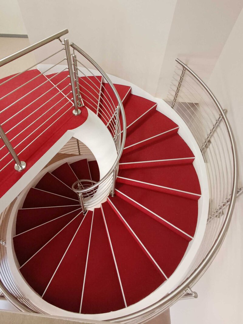 Helical staircase with red-carpeted steps | L'Elicoidale